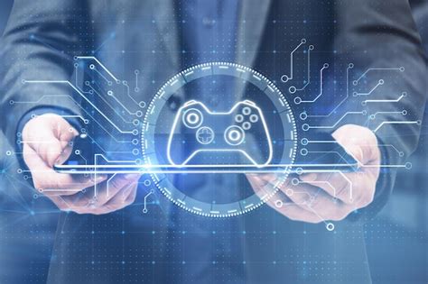 비즈니스맨의 손에 태블릿을 들고 있는 크리에이티브 조이스틱이나 게임패드 홀로그램이 흐릿한 사무실 인테리어 배경에 에스포츠 게임과 재미 콘셉트 더블 노출 프리미엄 사진