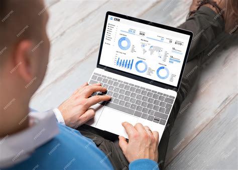 Premium Photo Man Using Crm Software On Laptop With Graphs And Charts