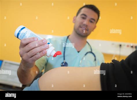 doctor applying gel to pregnant ladys bump for an ultrasound stock