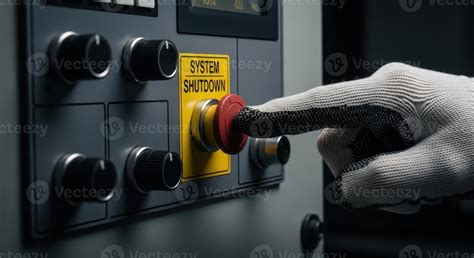 Gloved Hand Pressing Red Emergency System Shutdown Button On Industrial Control Panel 67243425