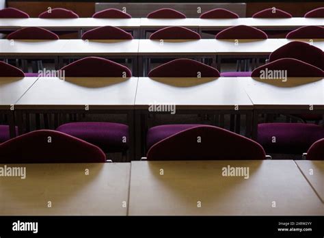 Inside A Classroom Or Lecture Room With Empty Rows Of Chairs Set Against Tables Stock Photo Alamy