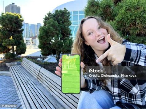 대도시를 걷는 동안 스마트 폰을 사용하여 헤드폰을 착용하고 대도시를 걷는 동안 도시 거리 고층 빌딩 배경에 서있는 십대 빨간 머리 소녀 전화 사용에 대한 스톡 사진 및 기타