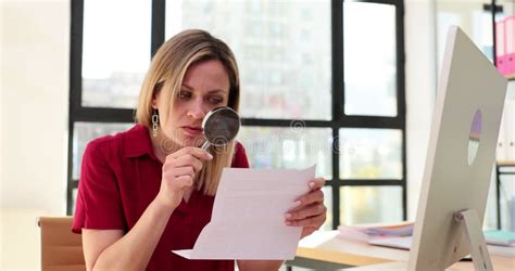Woman Uses Magnifying Glass To Read Information At Work Stock Footage