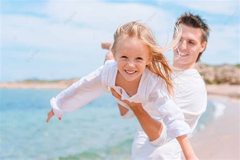 爸爸和女兒在海灘享受愉快的假期 照片背景圖桌布圖片免費下載 Pngtree