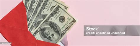 분홍색 배경에 빨간 봉투에 100 달러의 지폐비문 저축및 달러 지폐봉투 재정을 관리하고 비용 개념을 저장합니다 복사 공간 100