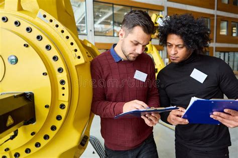 engineers programming robotic arm for industrial automation in modern