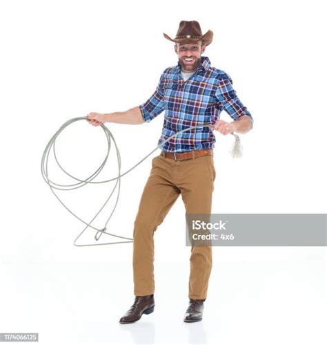 전체 길이 3039 세 성인 잘 생긴 사람 백인 남성 젊은 남자 카우보이 앞서 카우보이 부츠 카우보이 모자 모자를 입고 웃고 행복 쾌활 하 고 올가미를 들고 로프를 사용 하