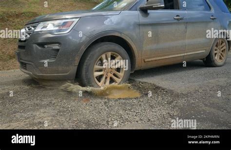 Close Up Tourist Suv Drives Into A Massive Pothole Gaping In The