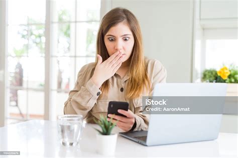 스마트 폰과 컴퓨터 커버를 사용 하 여 아름 다운 젊은 여성이 실수에 대 한 수치와 충격 두려움의 표현 침묵에 무서 워 비밀