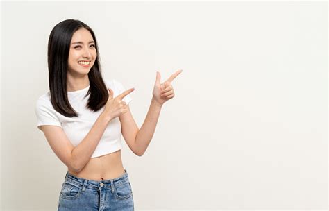 하얀 셔츠를 입은 행복한 아름 다운 아시아 여자가 손가락으로 공간을 복사한다 빈 공간을 가진 웃는 여성 아가씨 아시아의 귀여운 예쁜 사람들이 복사 공간 텍스트 광고를 찾고