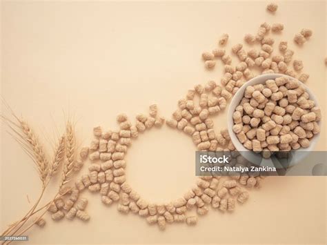 흰 판에 밀기울을 내밀고 테이블 위에 흩어져 텍스트를 위한 공간이 있는 원 모양의 빈 공간을 형성합니다 밀의 이삭 적절한 간식 적절한 영양 섭취 및 체중 감량의 개념