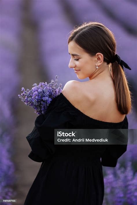 건강한 자연의 아름다움을 가진 젊은 낭만적인 여성이 라벤더 밭에서 꽃다발을 들고 카메라를 보고 웃고 있다 검은 드레스를 입고 머리를 숙이고 경치를 즐기는 아름다운 소녀 25