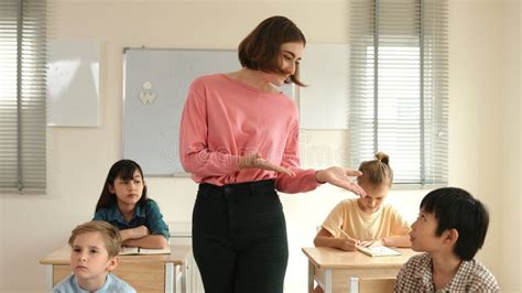 Caucasian Teacher Walking Around Classroom While Explain Classwork
