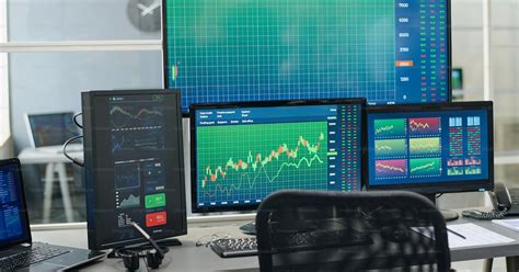 현대 사무실의 화면에 그래프가 있는 데스크톱 컴퓨터와 모니터가 있는 현대 투자 전문가의 작업 공간을 가로로 촬영하지 않습니다 사진 Unsplash의 기술 이미지