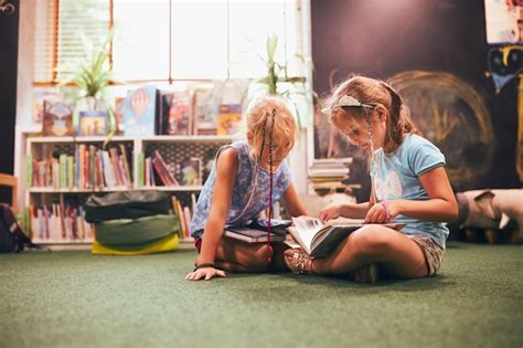 Premium Photo Two Primary Schoolgirls Doing Homework In School Library Back To School