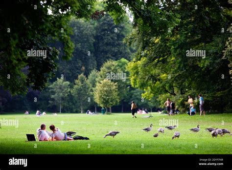 Germany Munich Couple On A Lawn In The Munich English Garden Englisher Garten Stock Photo Alamy