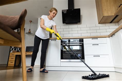 Photo Libre De Droit De La Femme Mûre Lave Le Sol Dans La Cuisine À Laide Dune Vadrouille Banque
