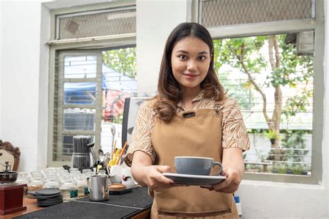 아시아 여성 바리스타가 커피를 제공합니다 프리미엄 사진
