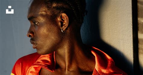 주황색과 노란색 재킷을 입은 남자가 벽에 기대어 있다 사진 Unsplash의 무료 초상 이미지