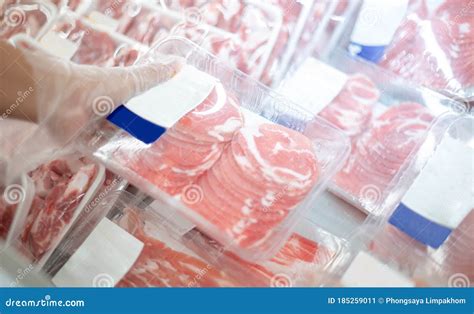 The Supermarket Employee Preparing The Fresh Pork Meat Slice On Display