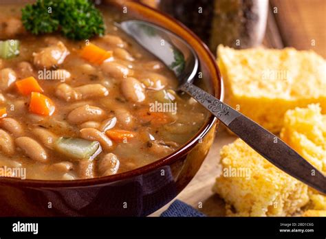 Closeup Of A Bowl Of Tasty Bean Soup With Cornbread On A Wooden Table
