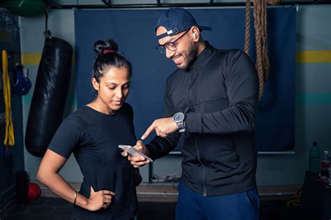 체육관에서 스마트 폰에 운동 계획을 만드는 여자와 개인 트레이너 무선 기술에 대한 스톡 사진 및 기타 이미지 무선 기술 인이어 이어폰 피트니스 강사 Istock