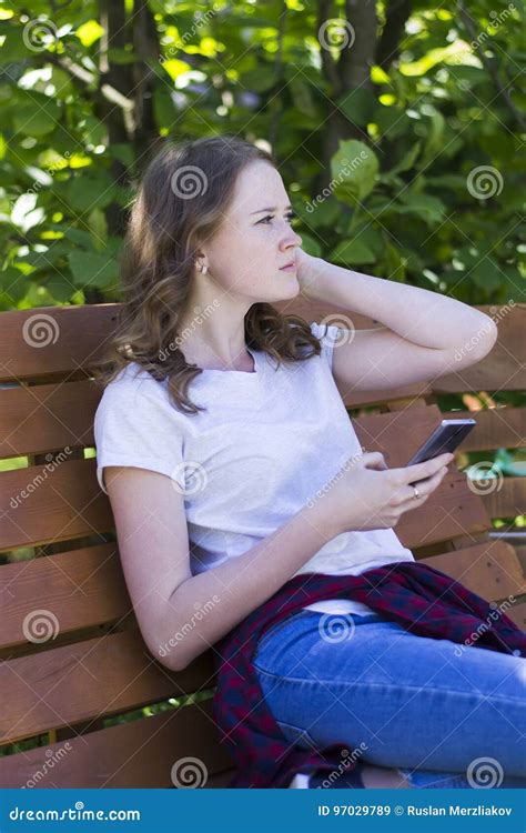 Meisje Met Een Telefoon Op Een Bank Stock Afbeelding Image Of Portret Kijk