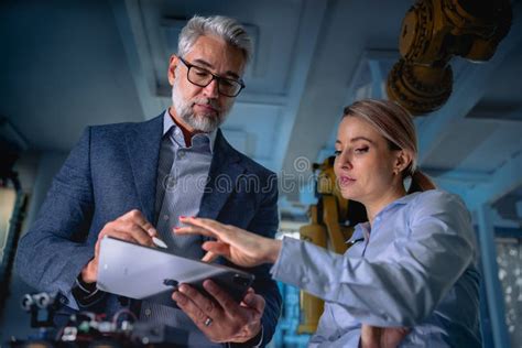 Two Robotics Engineers Working On New Project Standing In Laboratory