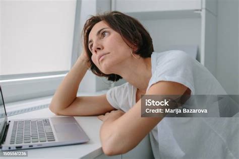 피곤하고 좌절하고 지치고 스트레스를받는 여자가 책상에 앉아 있습니다 직장에서 미루는 여성 일광 작업 흰색 티셔츠를 입은 소녀 35 39세에 대한 스톡 사진 및 기타 이미지