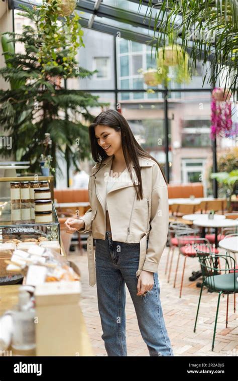 Brunette Young Woman With Long Hair In Beige Leather Jacket And Denim