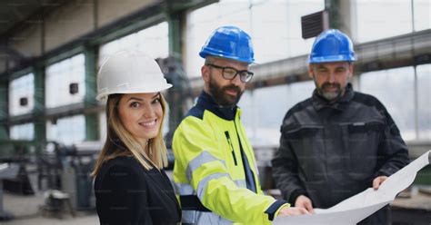 관리자 감독자 엔지니어 및 산업 노동자가 대형 금속 공장 홀에서 청사진을 논의하는 제복을 입고 있습니다 사진 Unsplash의 슬로바키아 이미지