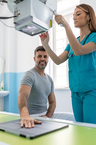 X선 기계 근처에서 환자의 손의 X레이를 준비하는 여성 방사선 전문의 거니에 누워 있는 환자의 엑스레이를 찍는 방사선 전문의 2명에 대한 스톡 사진 및 기타 이미지 Istock