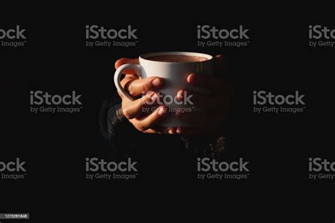 검은 색 배경에 커피의 흰색 컵을 들고 여성의 손 어둠 속에서 뜨거운 음료의 찻잔에 그녀의 손을 따뜻하게 여자 최소한의 스타일 공간을 복사합니다 낮은 키 커피 마실 것에
