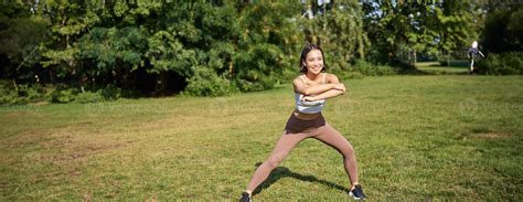 Young Asian Fitness Girl Stretching Workout In Park Showing Exercises