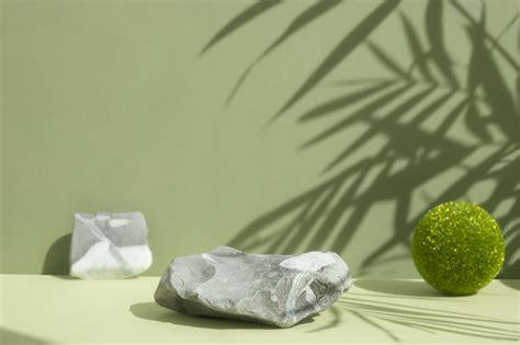 녹색 배경에 회색 돌로 만든 빈 연단에는 열대 나뭇잎 그림자가 있는 잔디 공이 있습니다 제품 미용 천연 에코 화장품의 홍보를 위한 장면 진열장 진열장 장식장에 대한 스톡