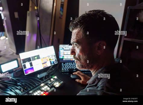 cybersecurity professional analyzing data on multiple screens in a low