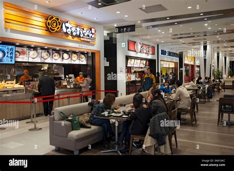 People Taking A Lunch Break At A Food Court Inside A Shopping Center