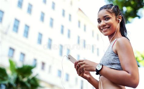 Never Miss A Beat While Out In The City Portrait Of An Attractive Young Woman Listening To