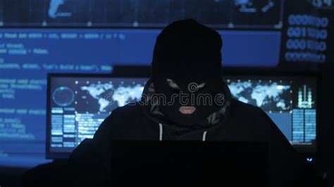 anonymous hacker in the mask tries to enter the system using codes and