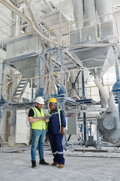 Premium Photo Two Young Intercultural Engineers Consulting Manual Guide In Digital Tablet