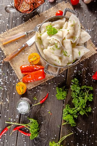 빈티지 소박한 그릇 접시 포크 나이프 숟가락 소금 향신료 신선한 허브 스탠드 와 거짓말 다른 각도 나무 절단 부엌 테이블에 어두운 빛에 빨간색과 흰색 생선 고기로 만든 만두