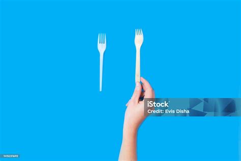 에코 천연 대나무 포크를 들고 있는 여자 손 플라스틱 포크 대 재사용 가능한 Bomboo 비교 개념 파란색 배경에 평평하게 누워