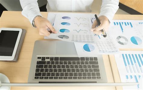 Premium Photo Businessman Analyzing Graphs And Using Laptop At Desk