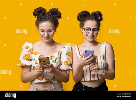 Curly Haired Fashionable Twins With Glasses Are Chatting On Mobile Wearing Summer Clothes On A