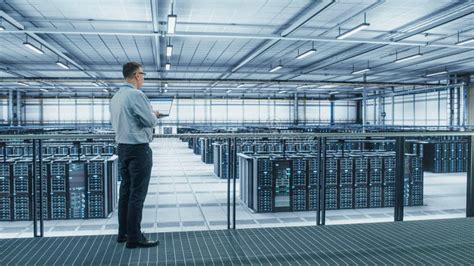Data Center Engineer Using Laptop Computer Server Farm Cloud Computing