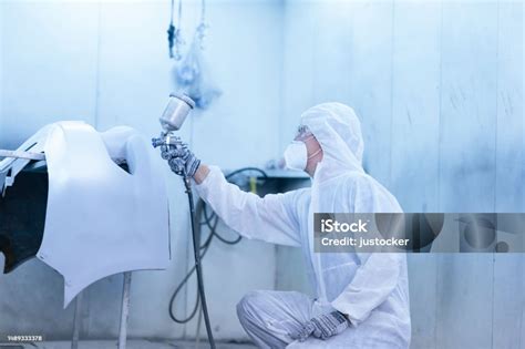 스프레이 건과 에어 브러시를 사용하고 자동차를 칠하는 작업자 챔버에서 자동차를 페인트 칠하는 기계공 차고 페인트 자동차 서비스 수리 및 유지 보수 40 44세에 대한 스톡