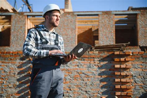 Architect Or Engineer On Construction Site With Laptop Monitoring Construction Process Stock