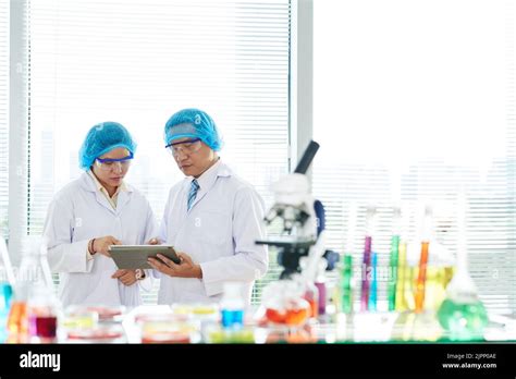 Confident Asian Scientists Wearing Safety Goggles And White Coats