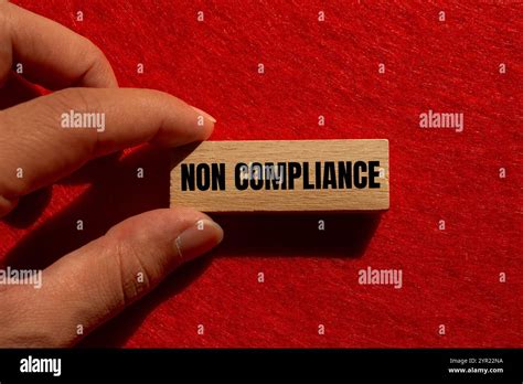 Non Compliance Message Written On Wooden Block With Red Background Conceptual Non Compliance