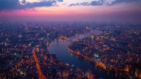 City Lights At Dusk Aerial View Of Urban Sprawl And River Bridges Under